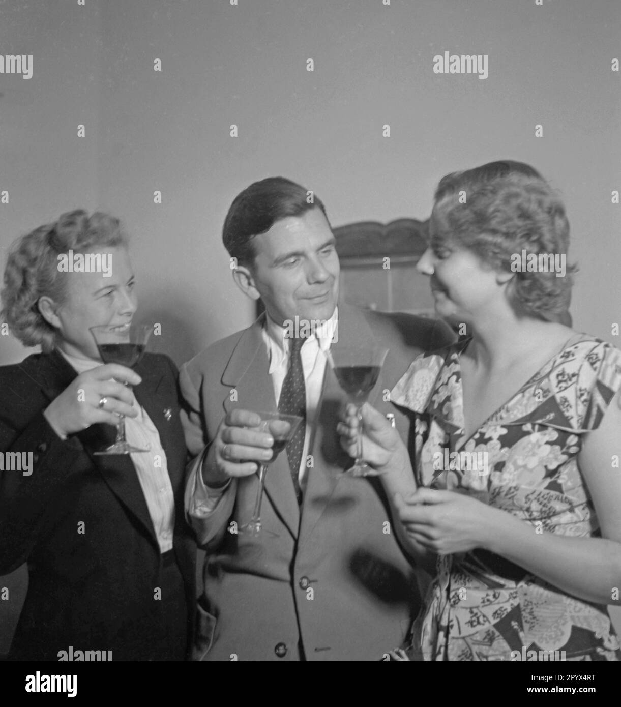 A man drinks a liqueur with two women. Undated picture, probably from ...