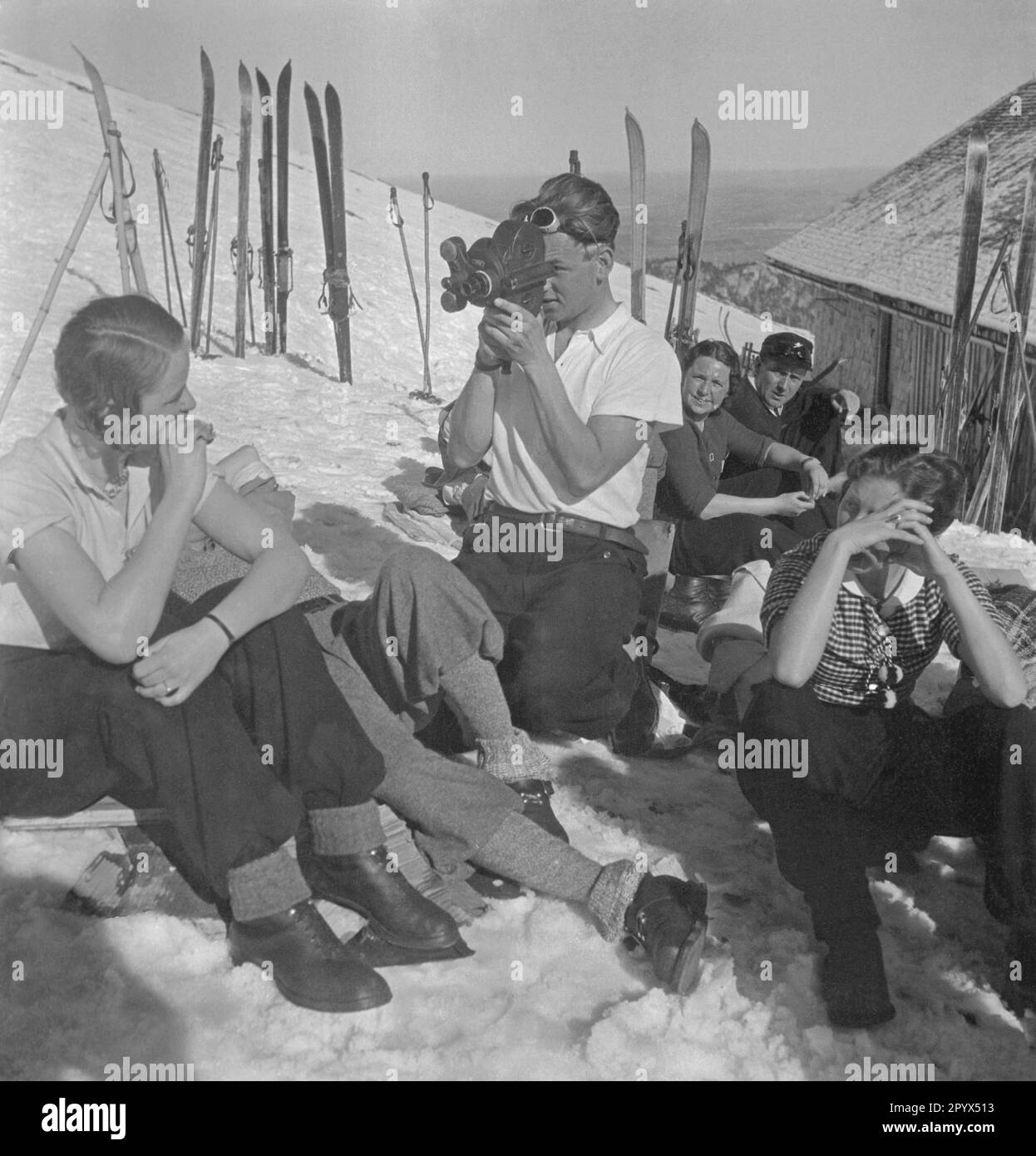 "A cameraman films a girl during a break on a high alpine pasture at a ...