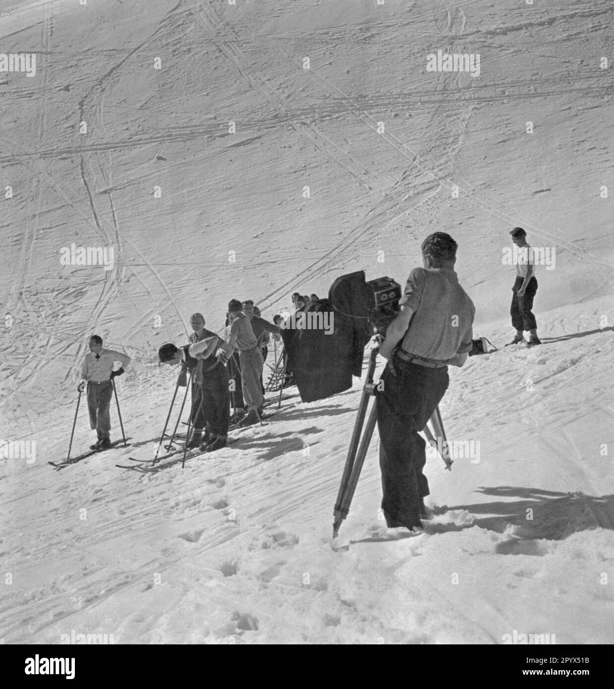 "A cameraman films a group of skiers on a high alpine pasture at a ...
