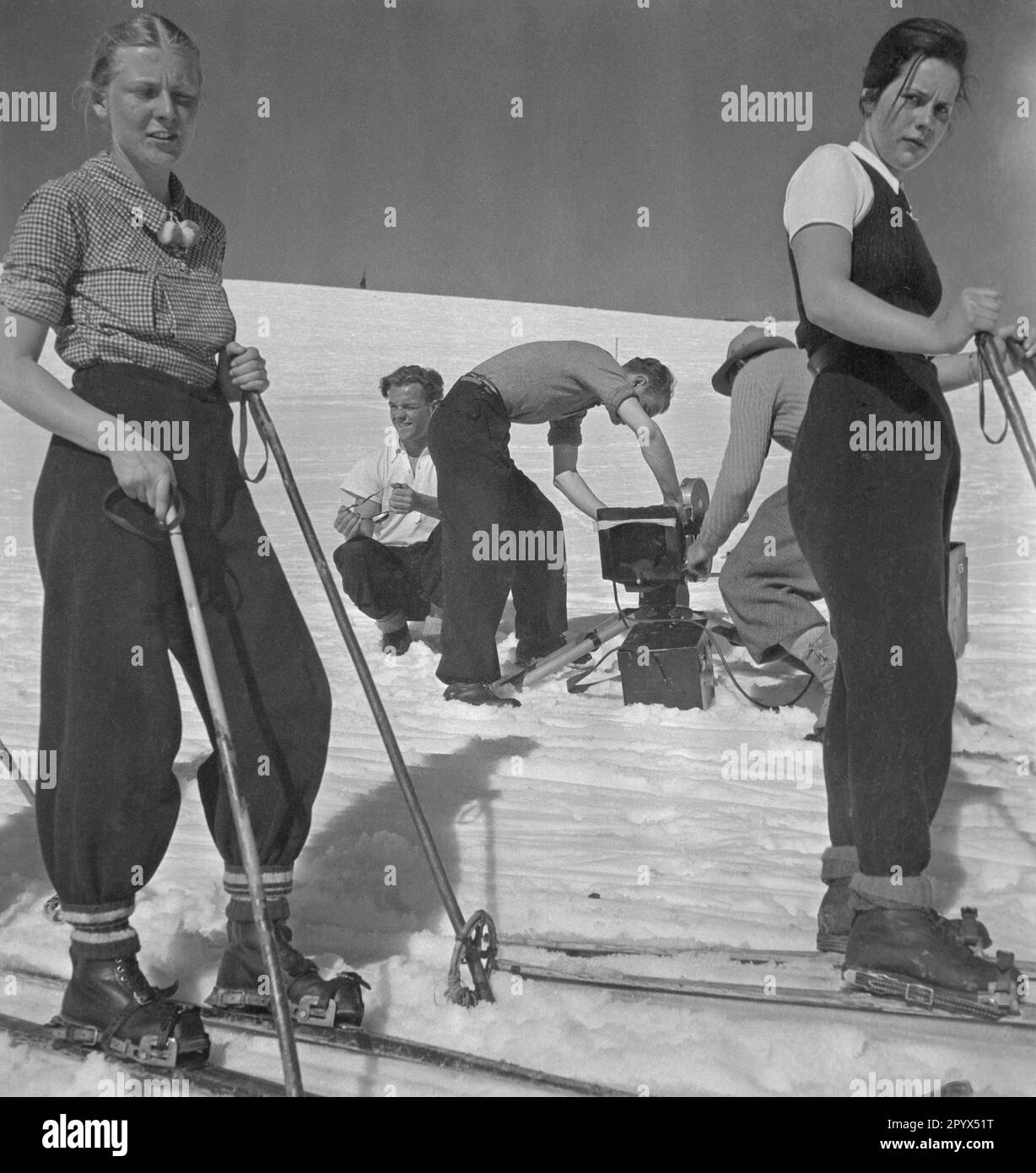 "A cameraman sets up his camera to film a group of skiers on a high ...