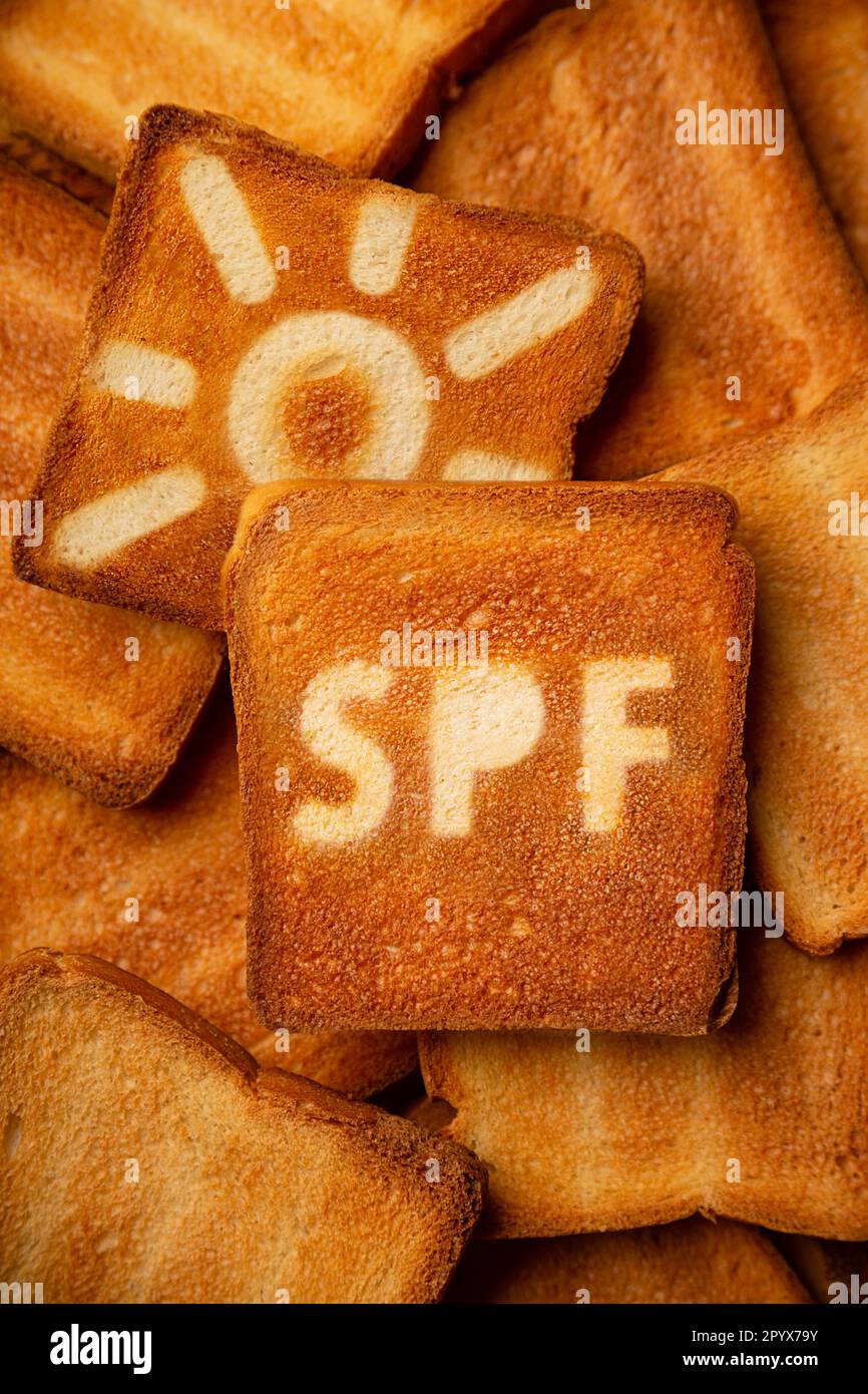 Concept of SPF cream and sun sign on toasted bread background Stock ...