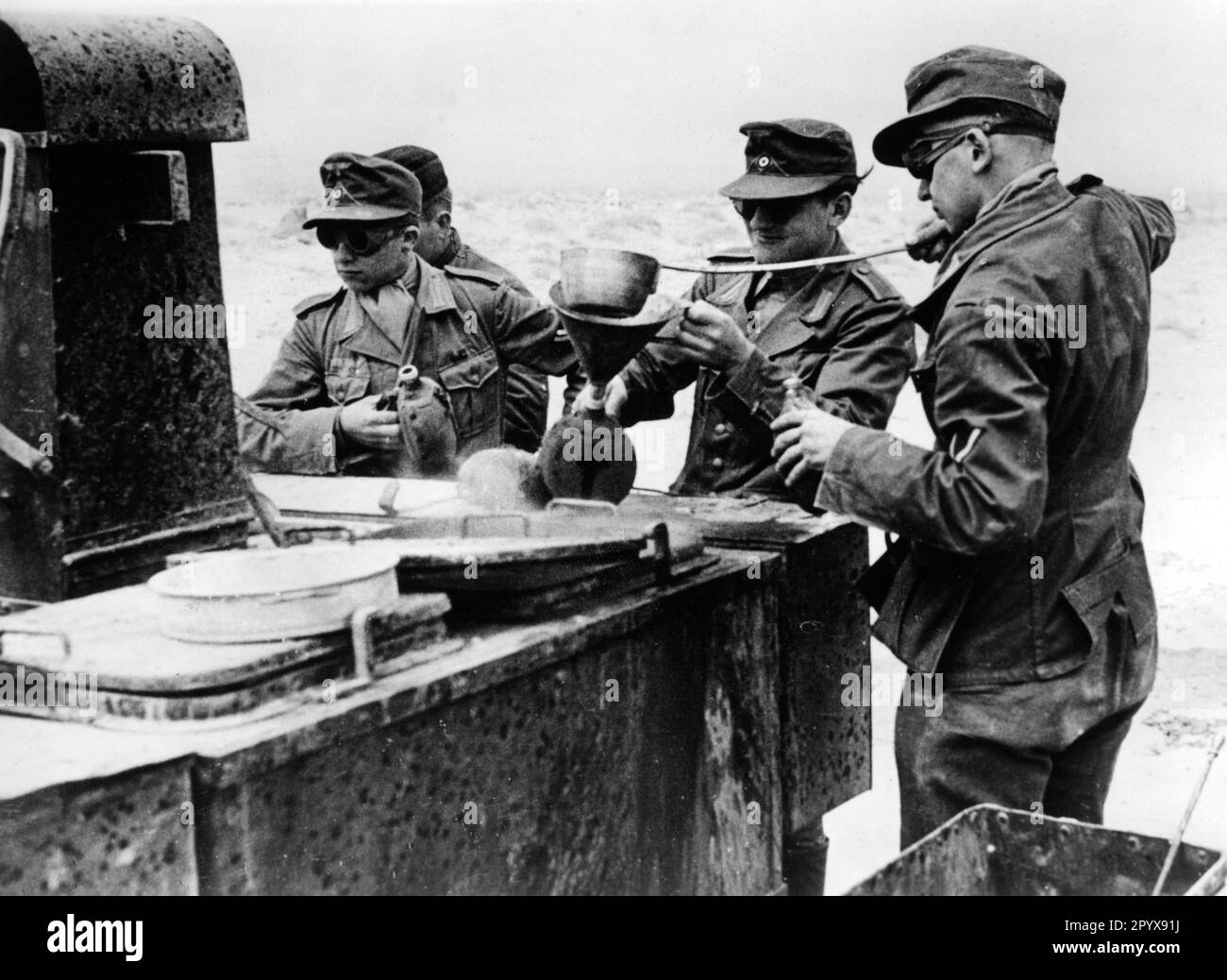 Soldiers of the German Afrika Korps stand at a food distribution in ...