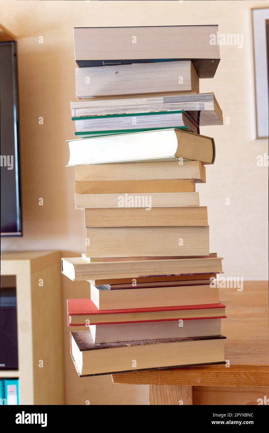 A Tall Stack Of Books On The Edge Of A Table Stock Photo - Alamy