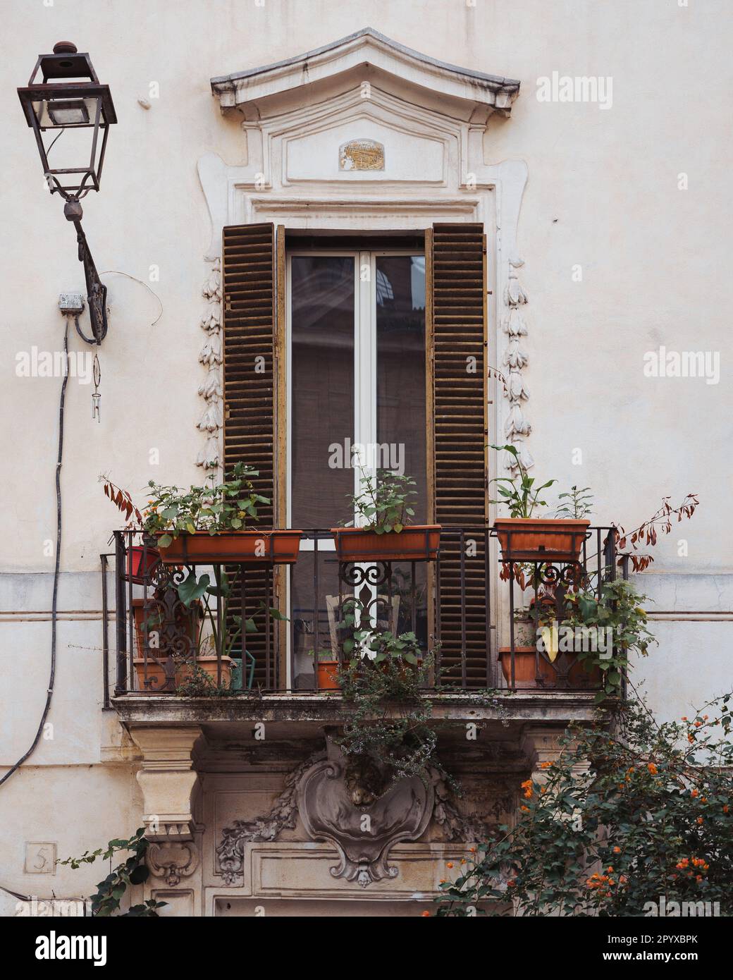 A traditional-style window with wooden shutters and a flower box ...