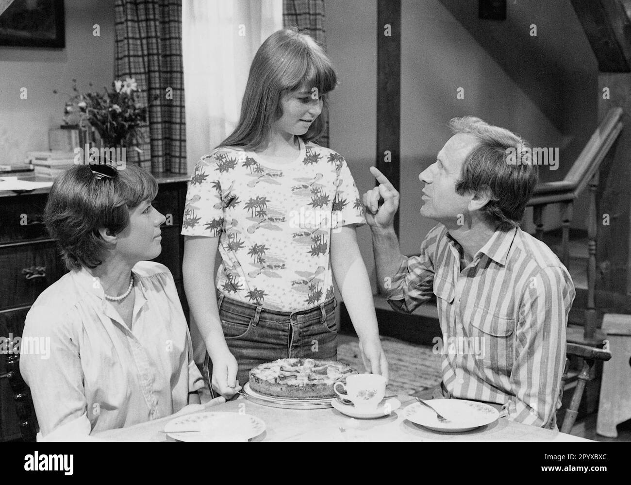 Mother and father sit with their daughter over coffee and cake. Ilse ...