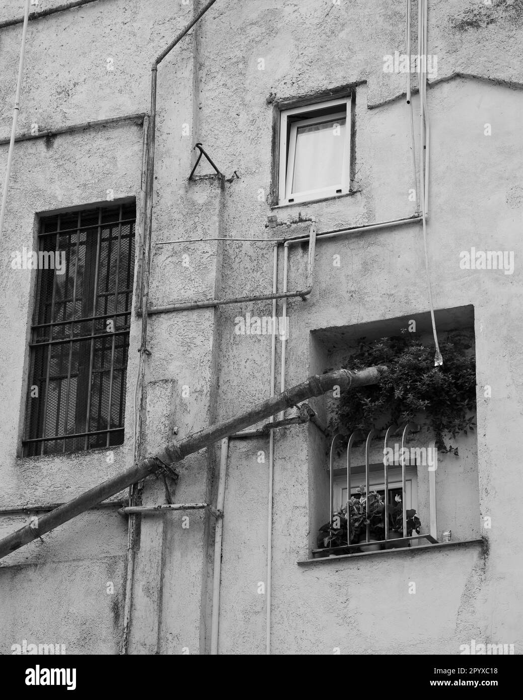 A facade of an old building with windows Stock Photo - Alamy