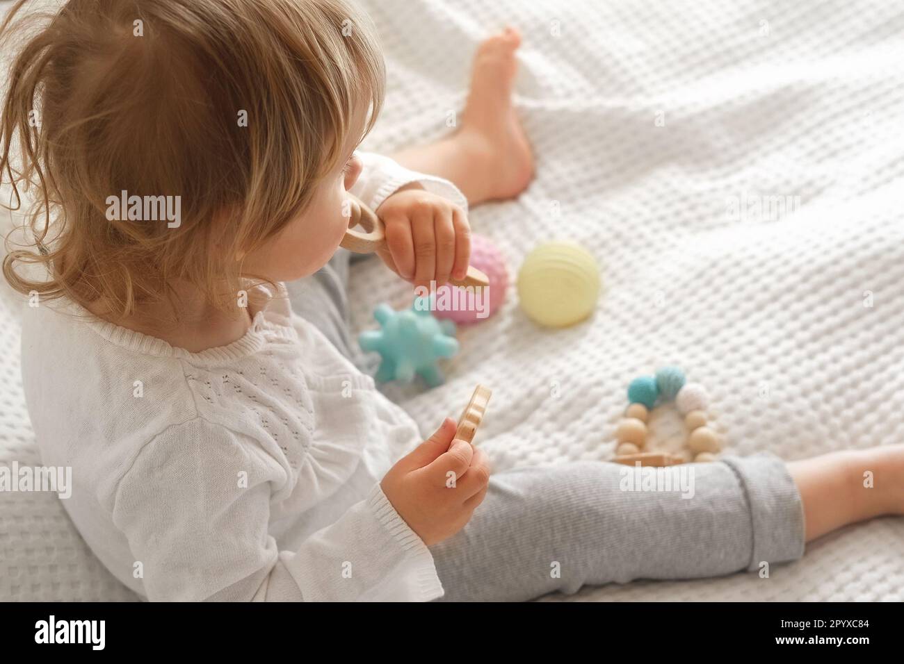 Cute baby girl playing tactile wooden and silicone toys. Young child ...