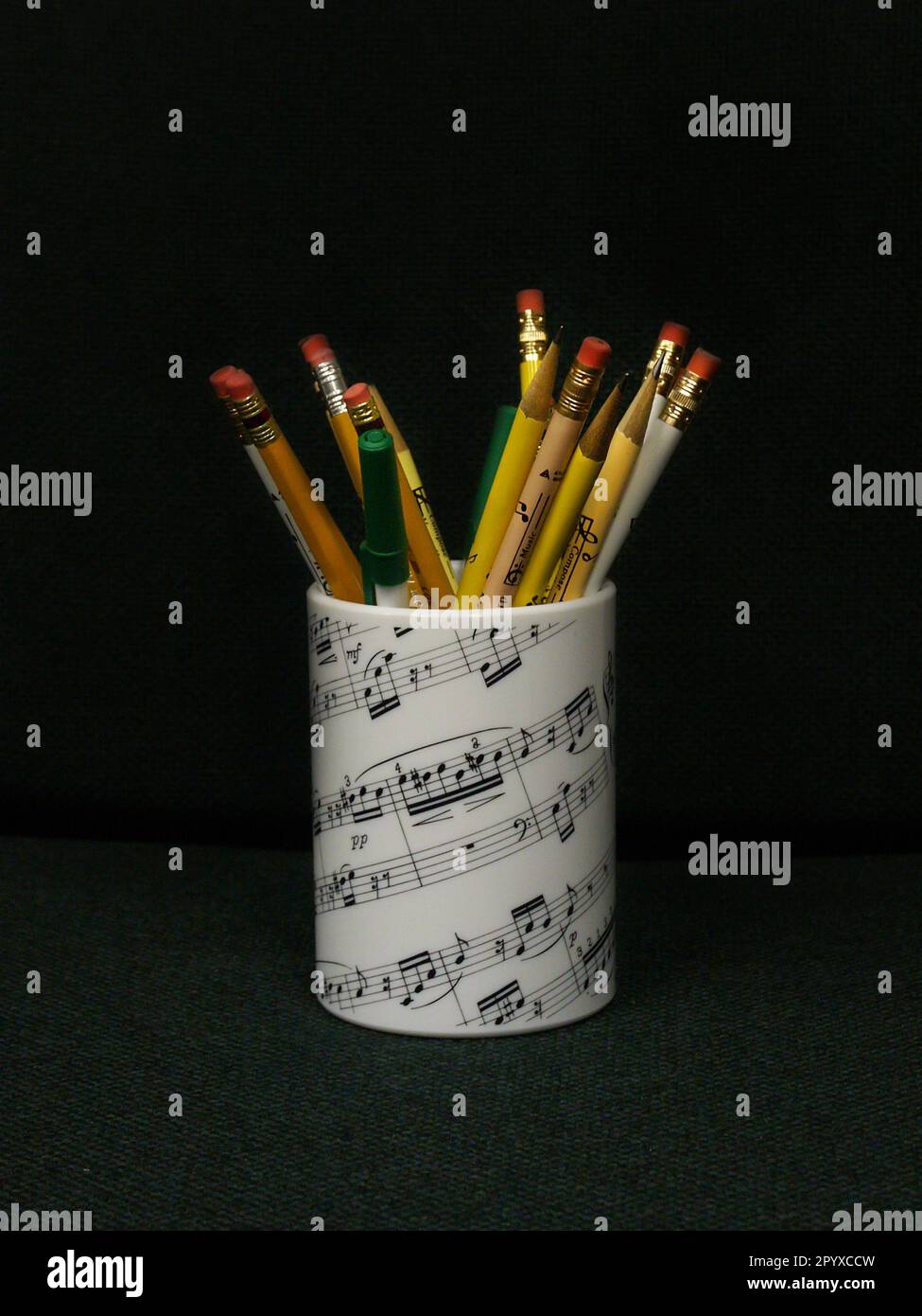 Coffee cup decorated with musical notes is full of pencils Stock Photo ...