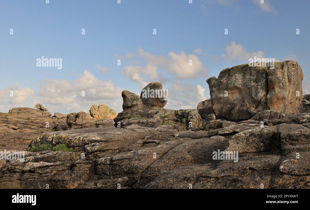 A scenic landscape featuring large rocks situated in the center of a ...