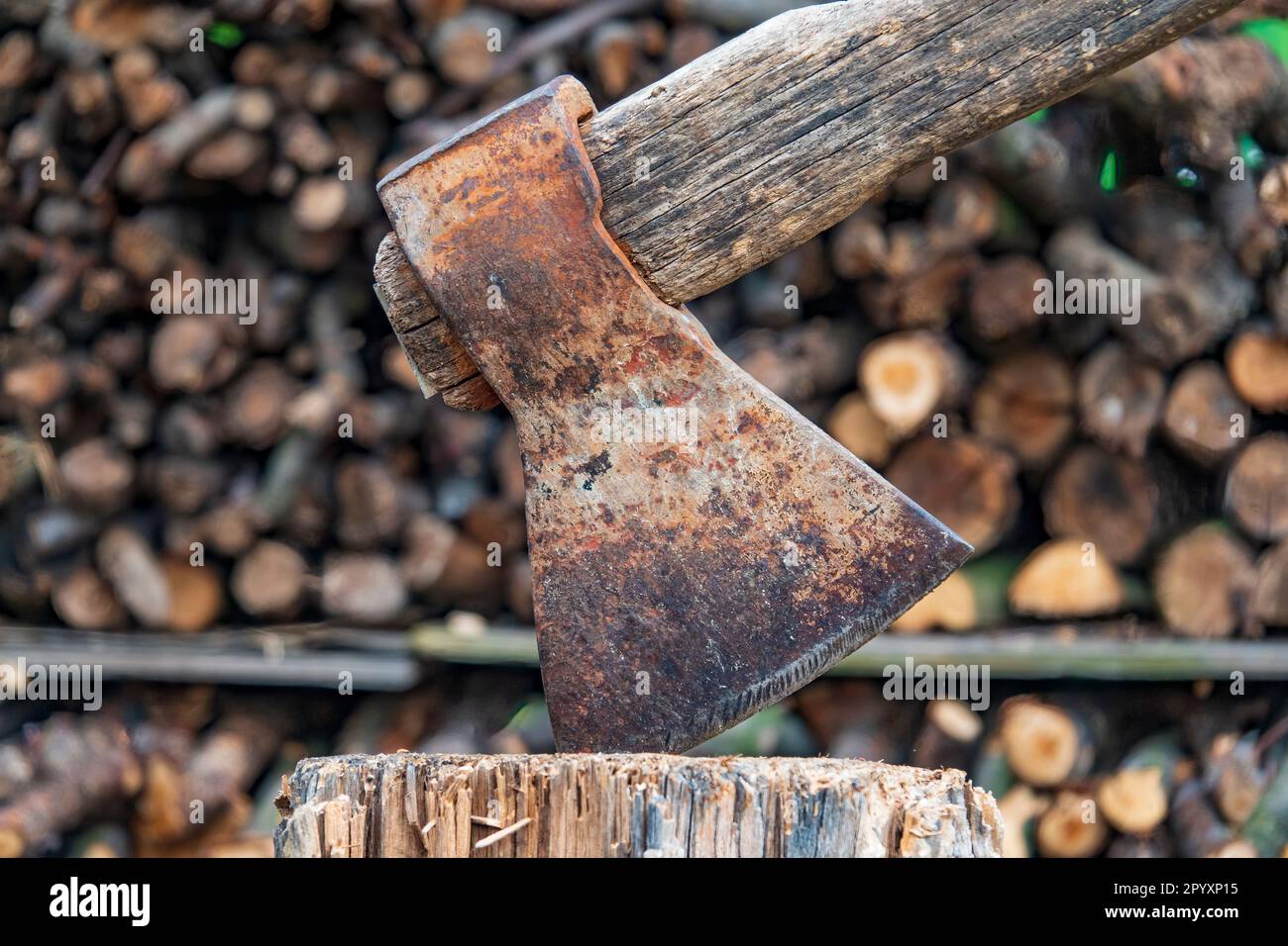Old rusty axe with firewood stacks on the background Stock Photo - Alamy