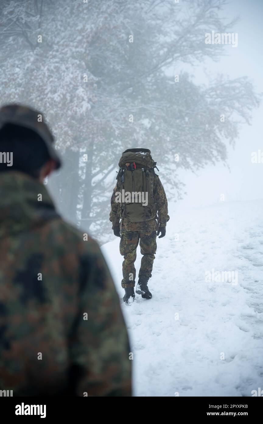 A vertical shot of German soldiers at a march during the snowfall in a ...