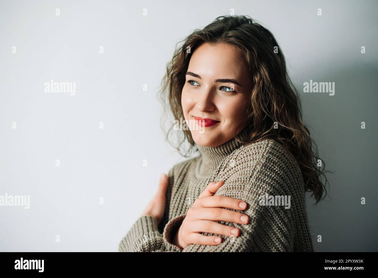 Romantic wife eagerly anticipating husband's return, standing by window ...