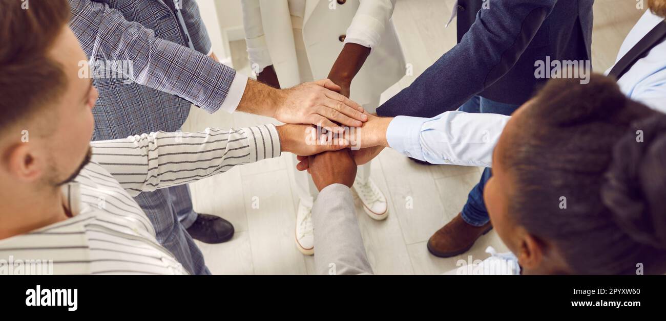 Close up top view photo of diverse business people putting their arms ...