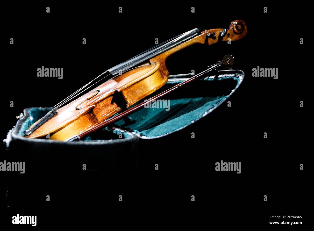 small model of an old violin with bag on black surface with black ...