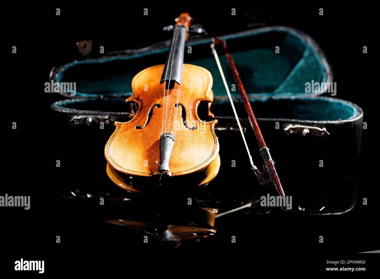 small model of an old violin with bag on black surface with black ...