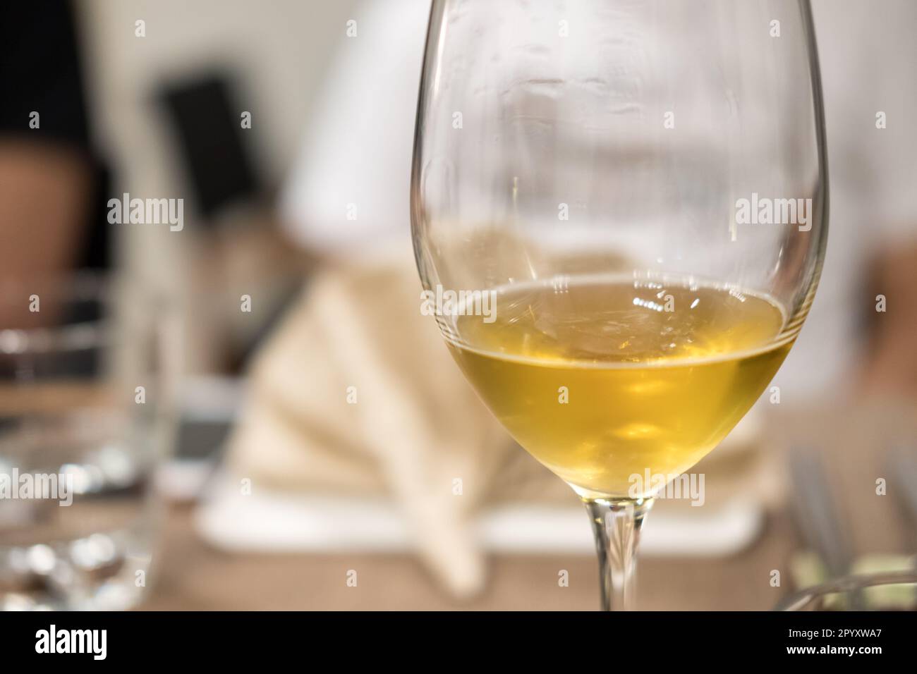 A glass of wine on the table, with blur background in the restaurant ...