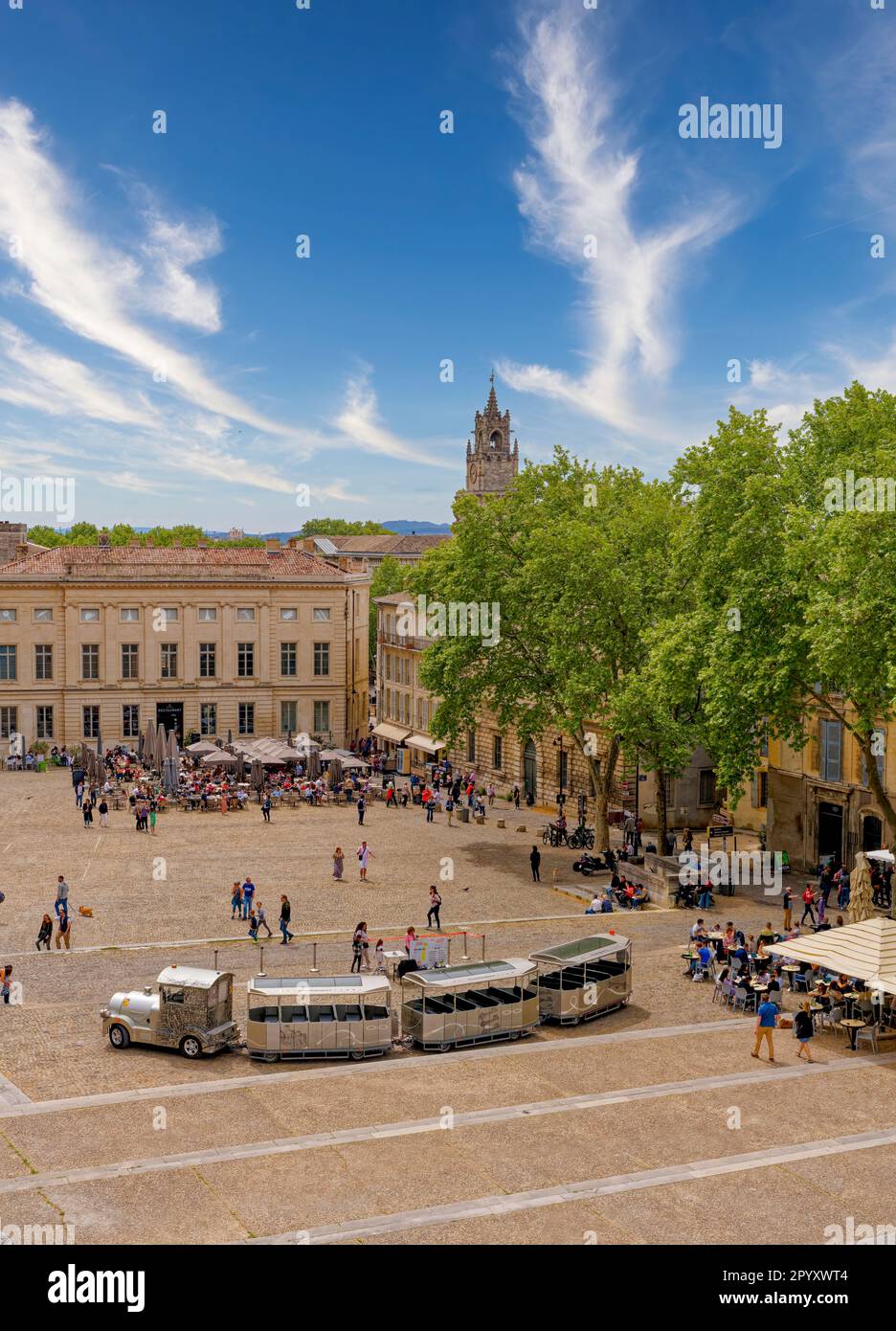 Under a bright blue sky, the view looking down into the town square of ...