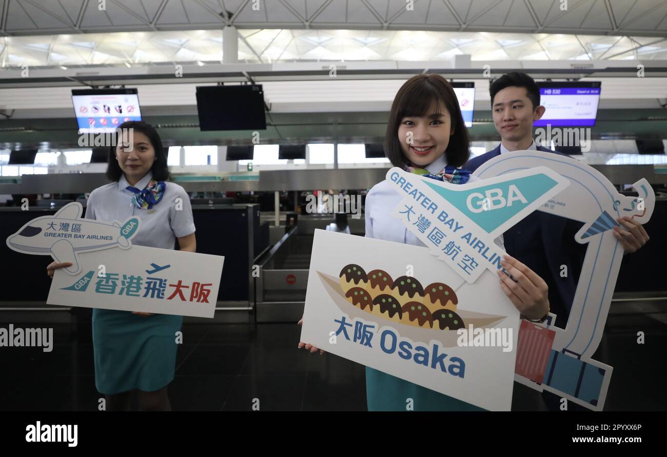 Greater Bay Airlines (GBA) crew members welcome passengers to check in ...