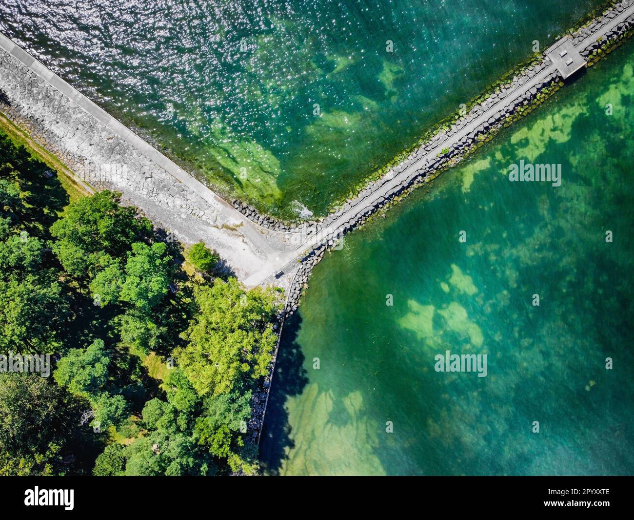 Aerial view of a pier leading to a road extending over a tranquil ...