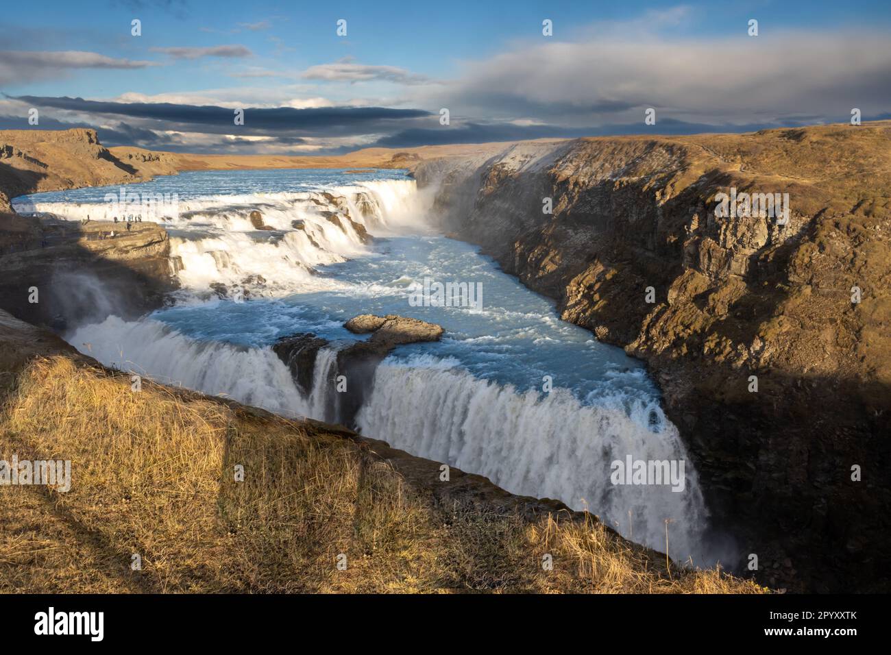 Famous part of the golden circle. Two cascades of the Gullfoss waterfall, surrounded by cliffs ...