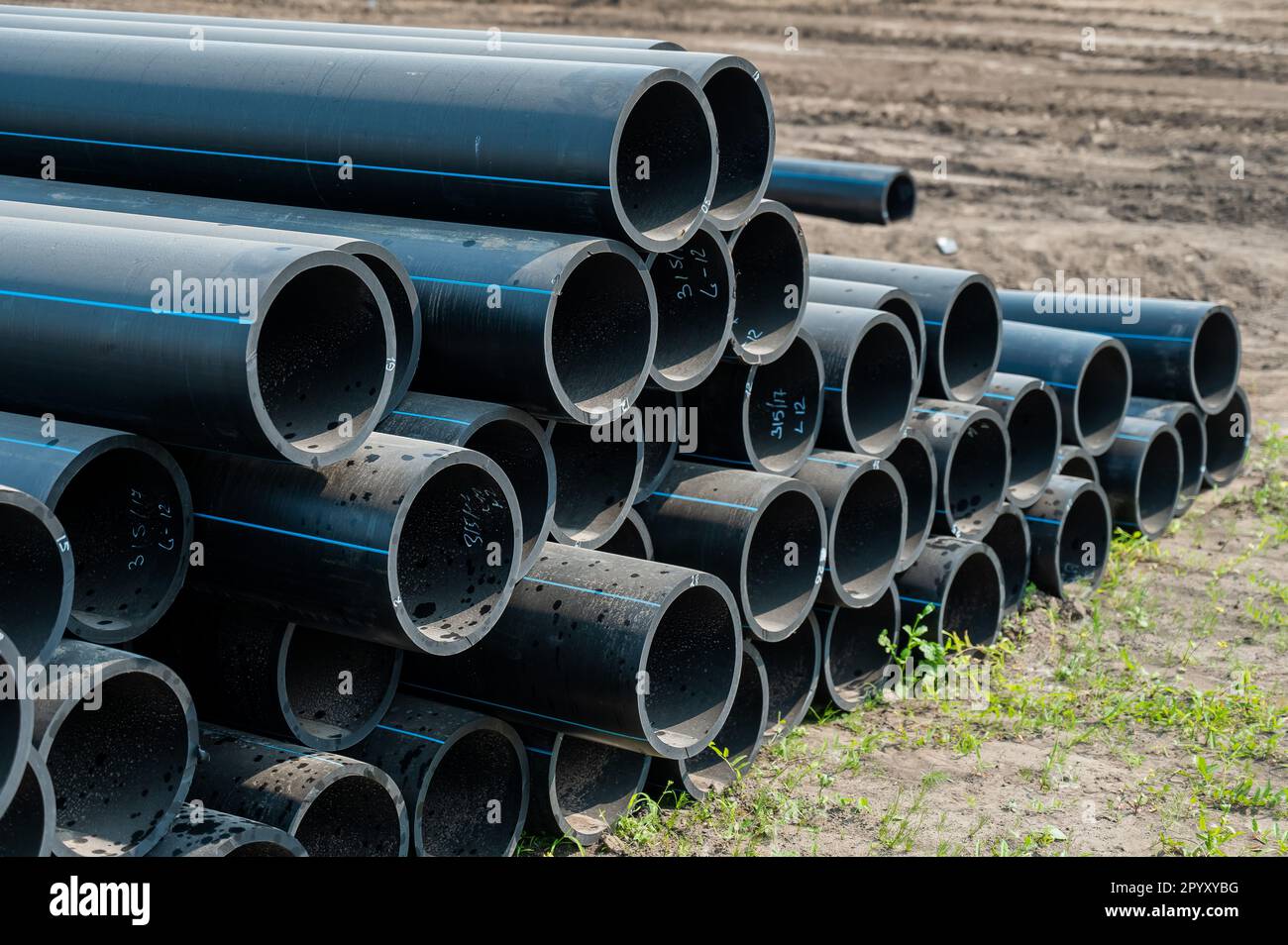 Pile of pipes on the ground at a construction site Stock Photo - Alamy