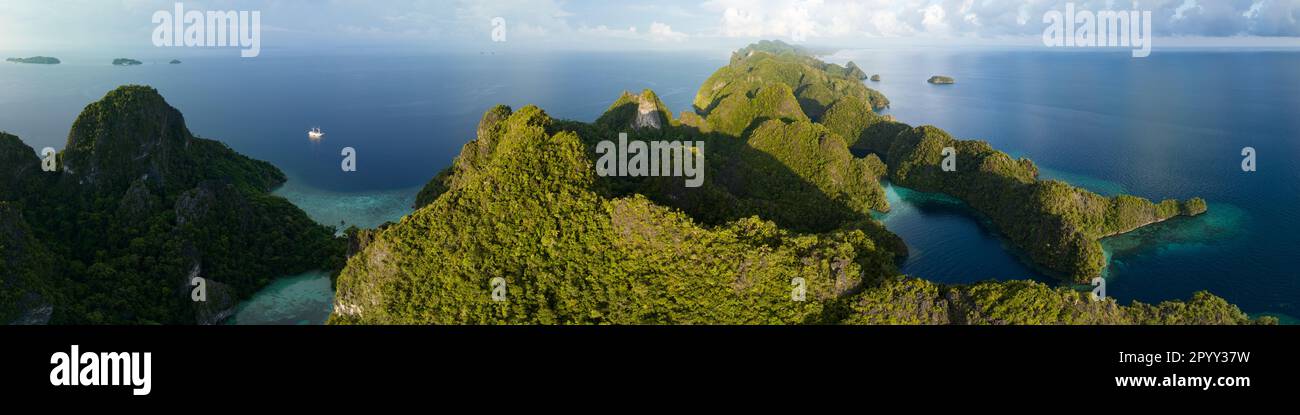 Coral reefs surround the rugged limestone islands that rise from Raja ...