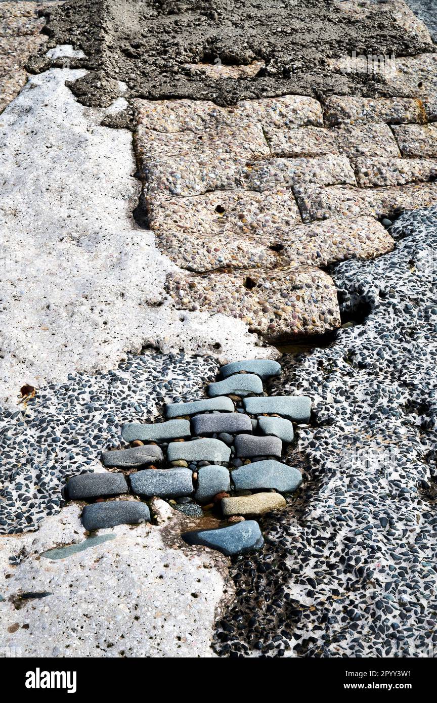 Piecemeal repairs carried out on seawall using different concretes and ...