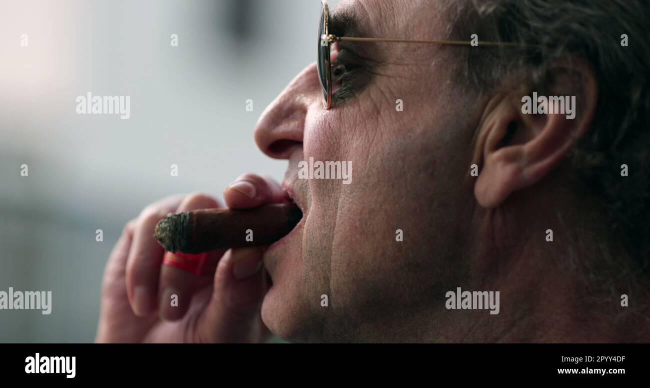 Older man enjoying cigar outside. Senior man smoking cigar Stock Photo - Alamy