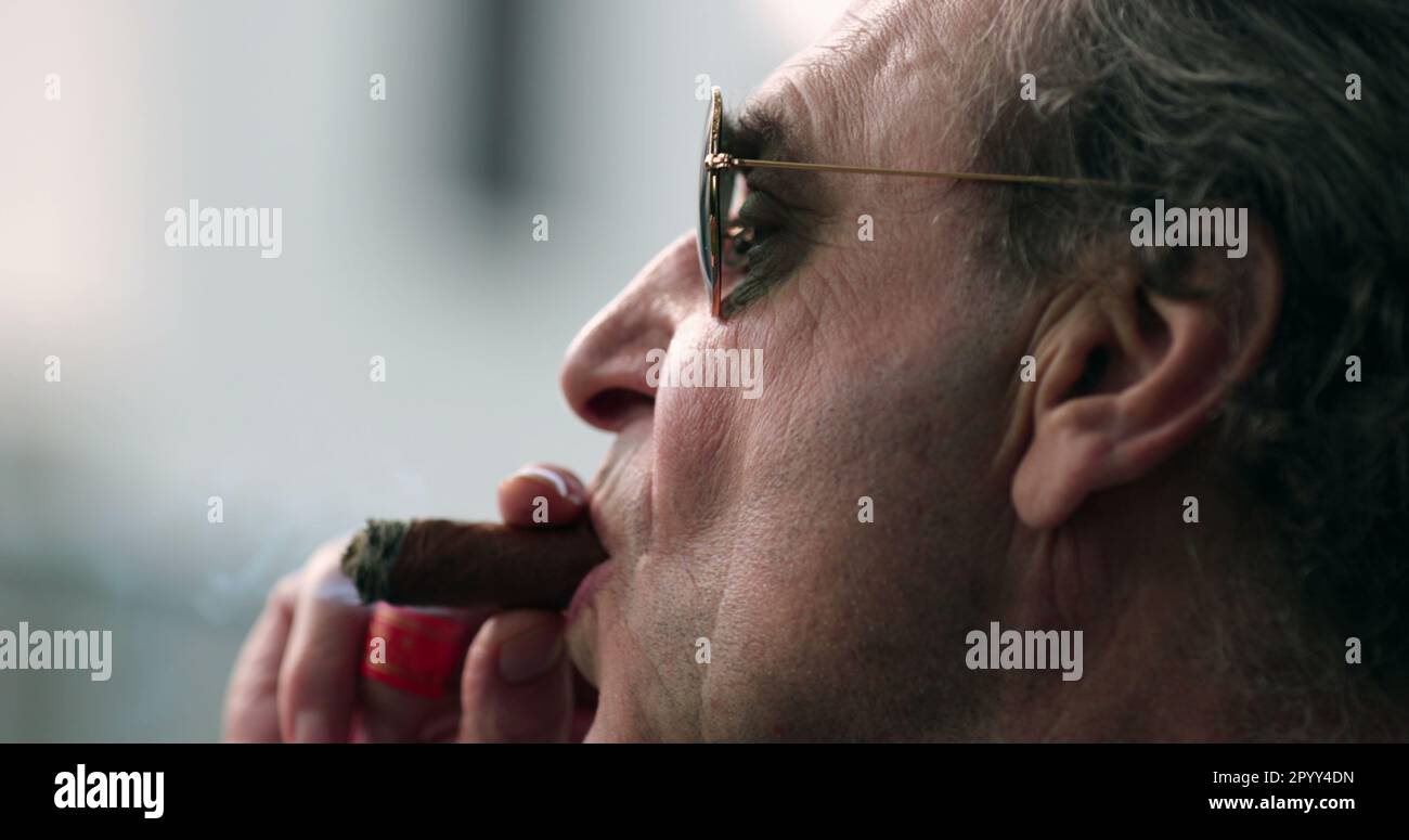Older man enjoying cigar outside. Senior man smoking cigar Stock Photo ...