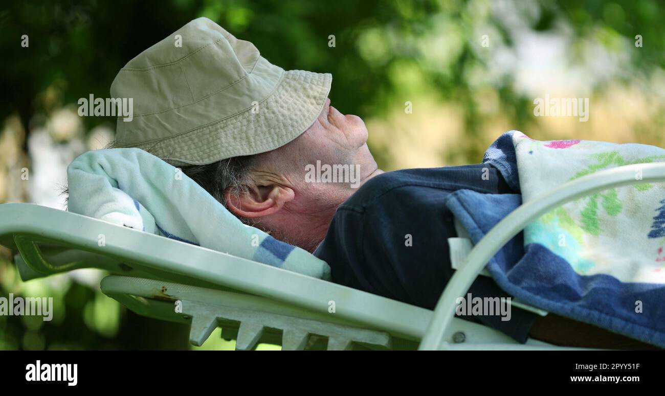 Older man sleeping under tree. Senior retired man napping outside Stock ...