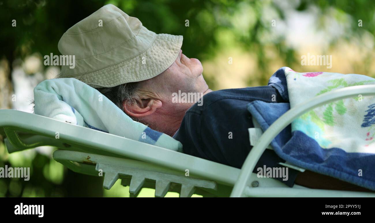 Older man sleeping under tree. Senior retired man napping outside Stock ...
