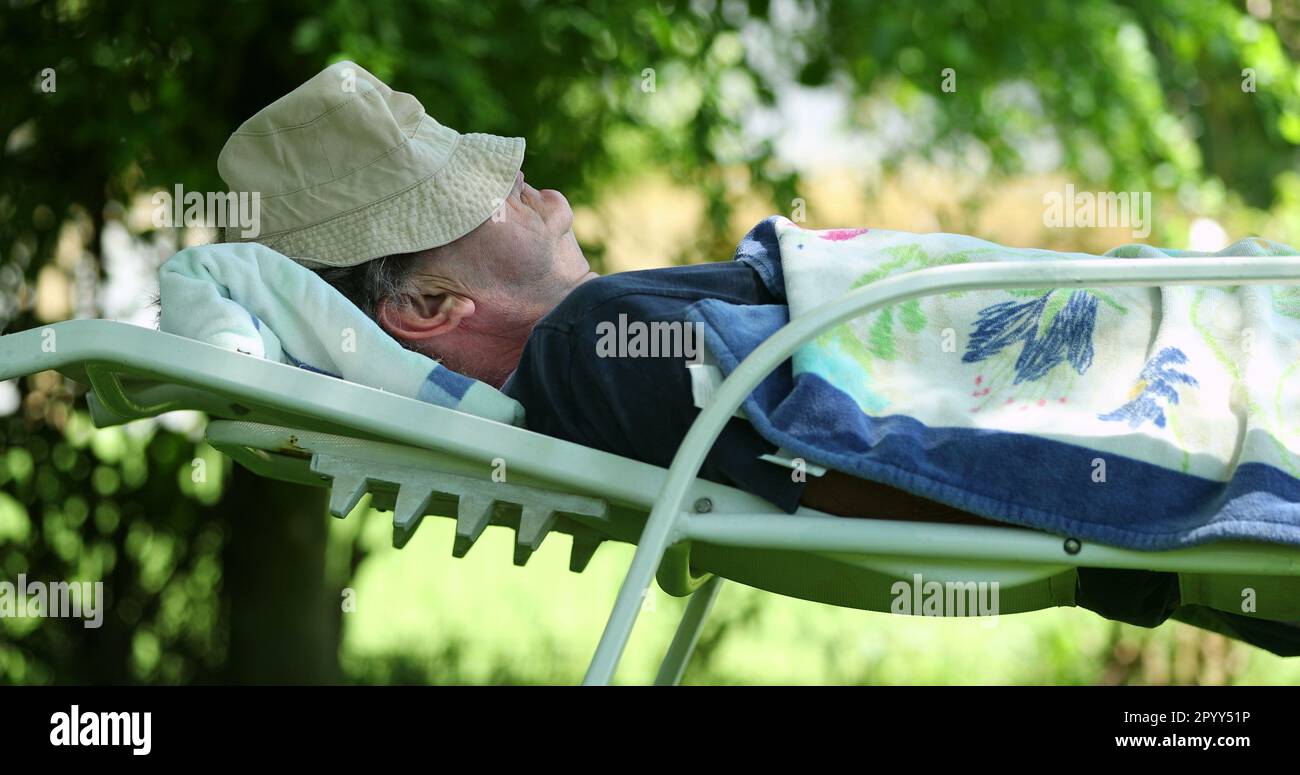 Older man taking a nap outside in nature. Senior retired person ...