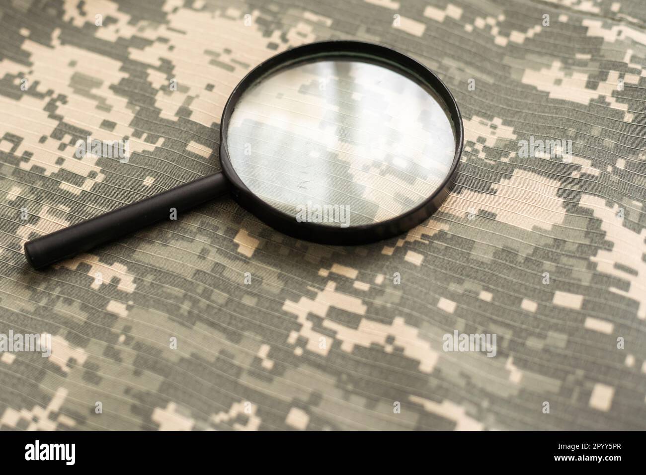 black magnifier on green military uniform Stock Photo - Alamy