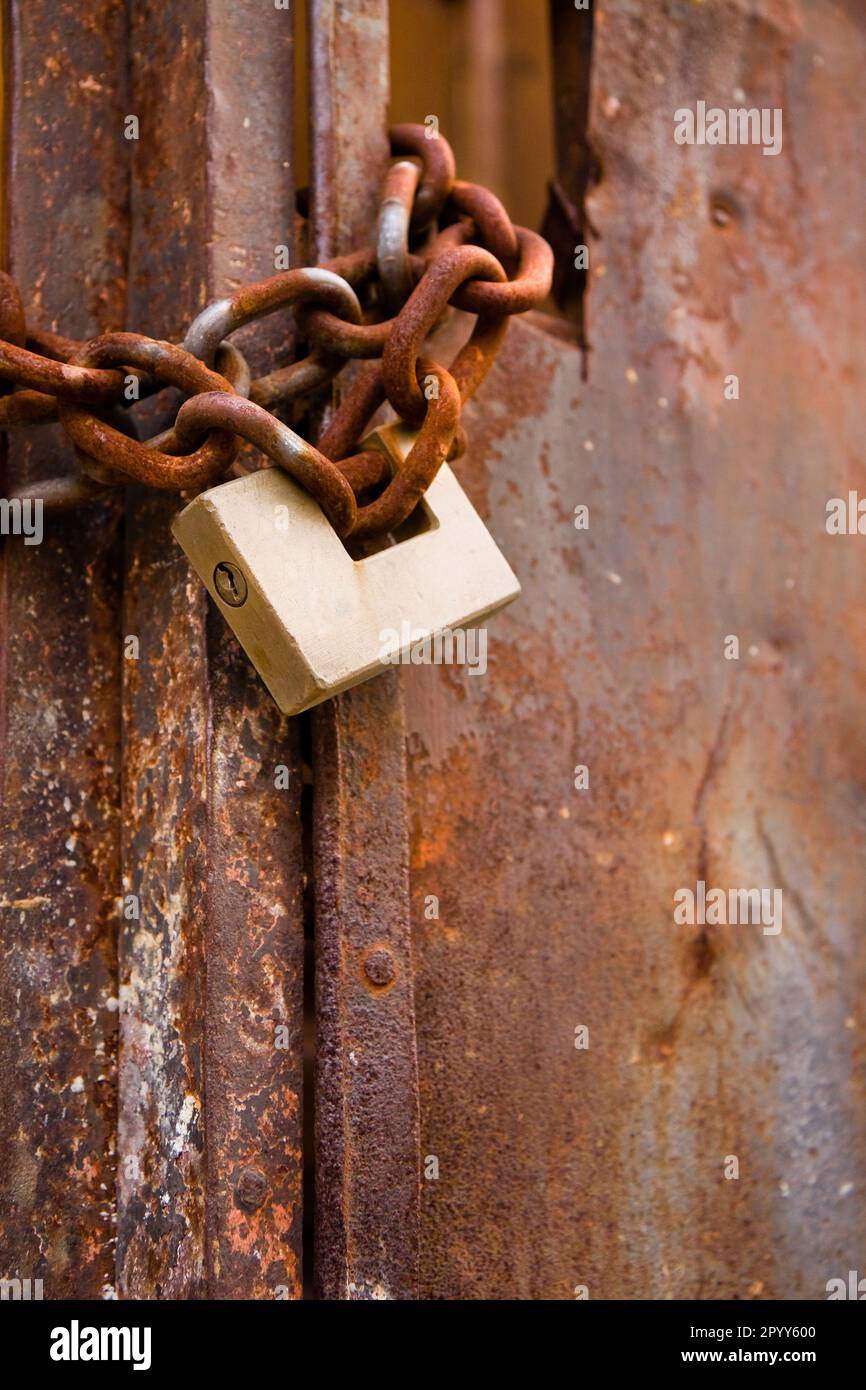 Rusty metal gate of a factory closed with padlock - concept image Stock ...