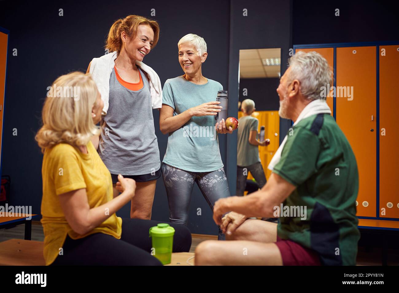 Horizontal shot of people in locker room, senior man and two women with ...