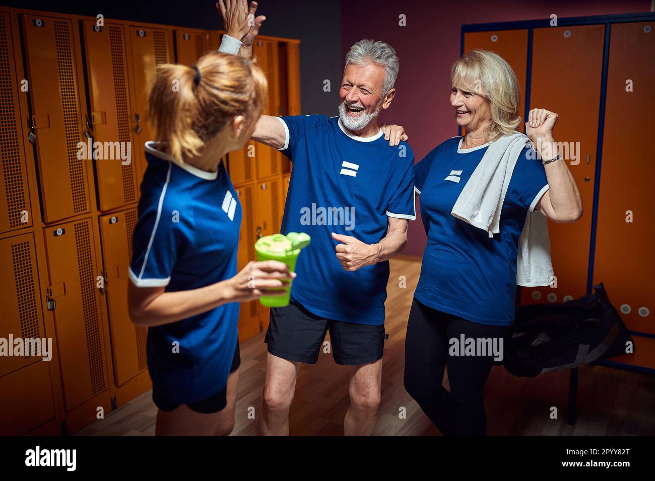 Sports team in locker room feeling joyful and victorius, young woman ...