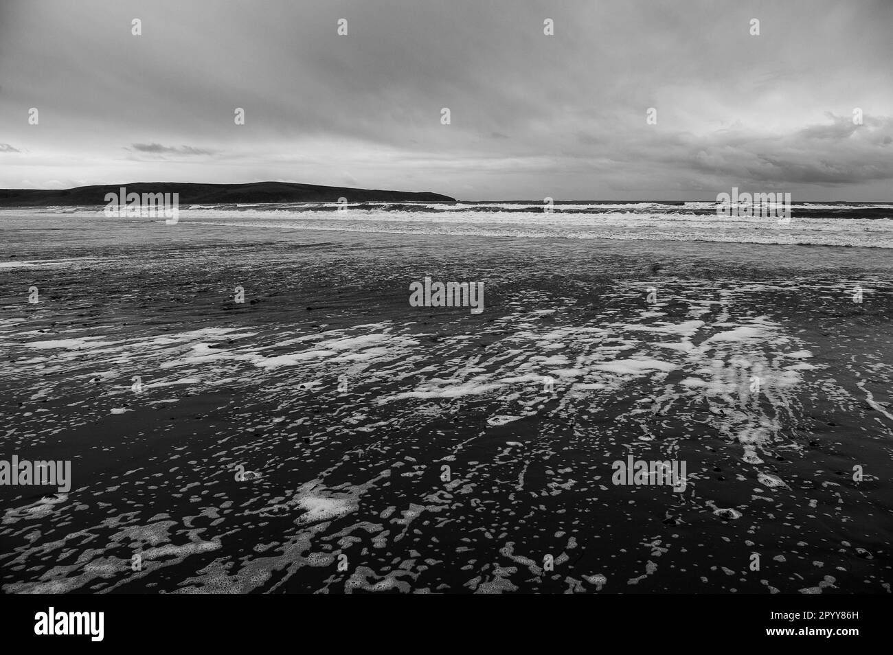A breathtaking scene of the ocean waves crashing onto a sandy beach ...