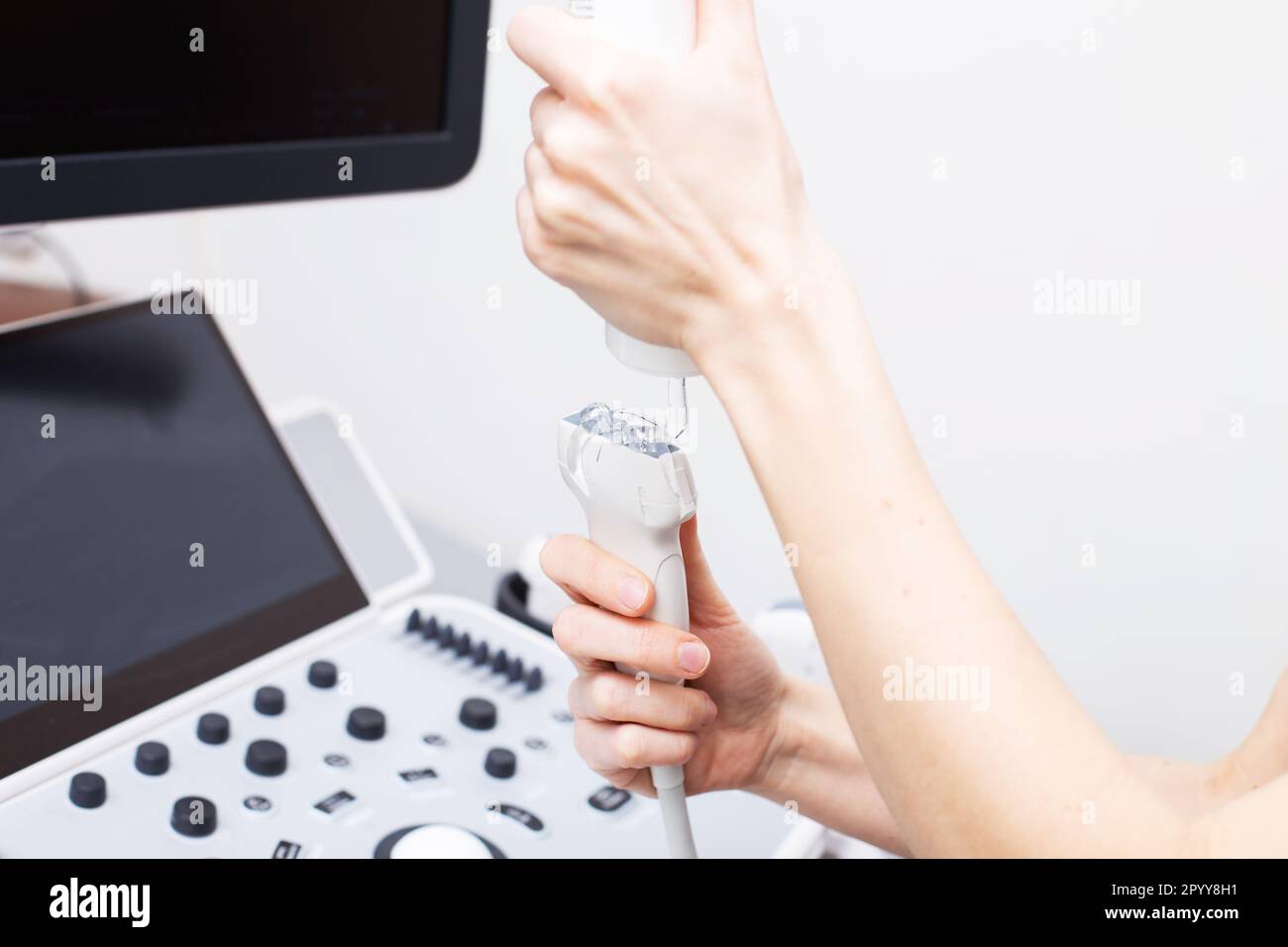 Woman doctor's hand applies a medical gel to ultrasonic sensor of ...