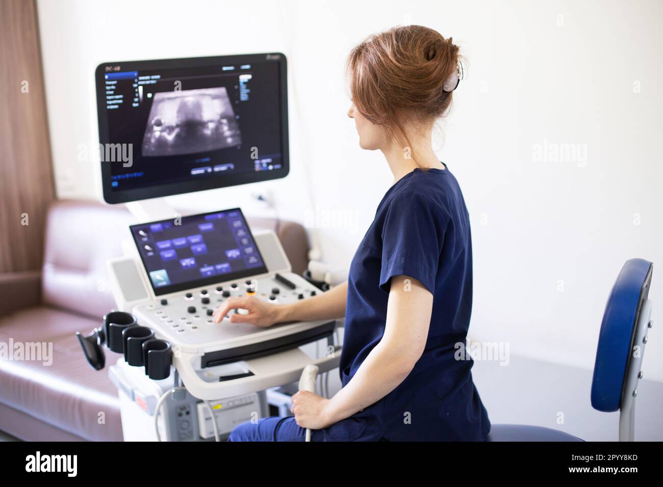 Doctor Woman Doing Ultrasound Scanning Diagnostic Of Thyroid Gland
