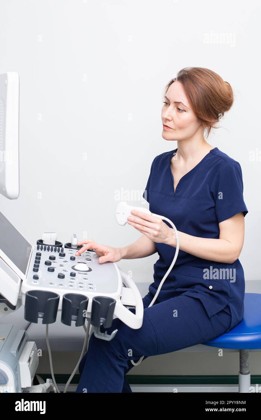 Female doctor sitting in office in a hospital doing ultrasound scanning ...