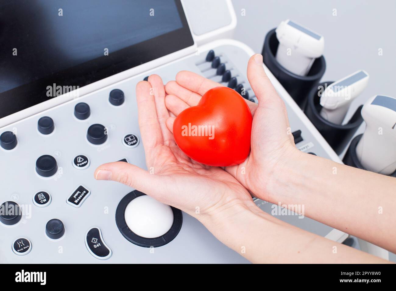 Hands of ultrasound diagnostic doctor holding heart near ultrasound ...