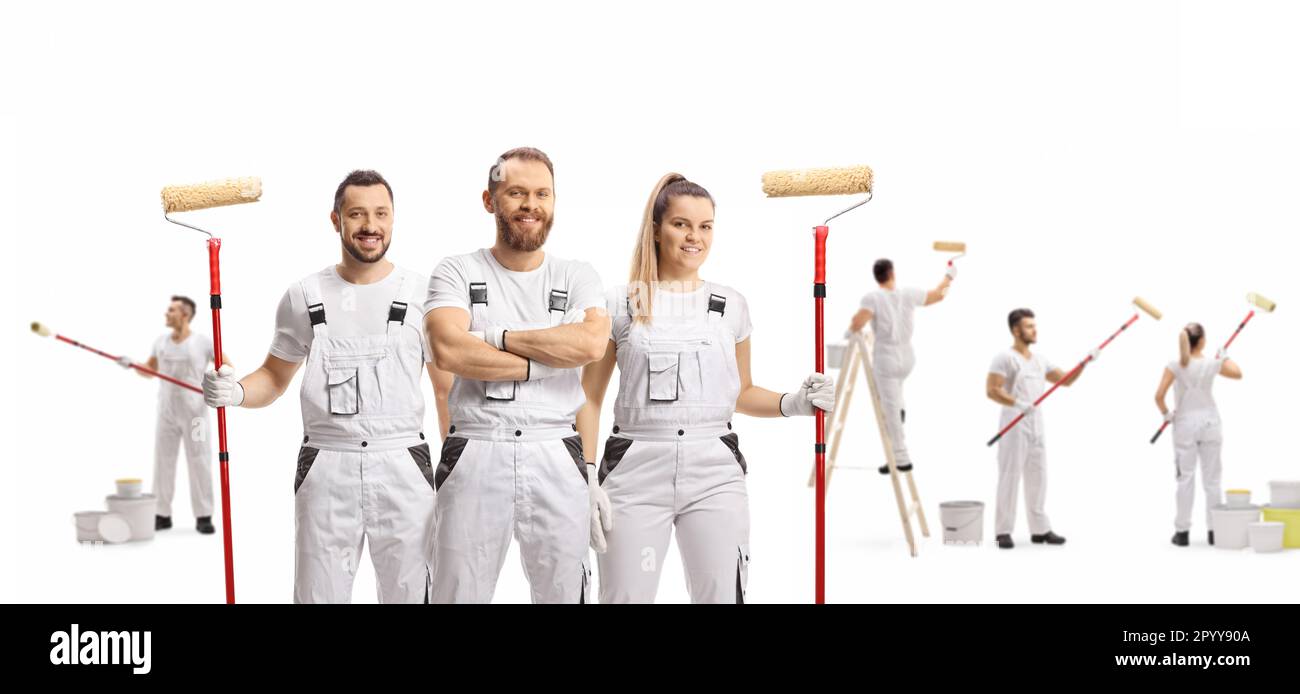 Team of professional painters decorating a wall and posing isolated on ...