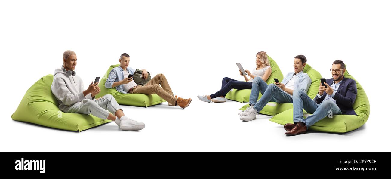 Young People Sitting On A Bean Bag Armchairs And Using Smartphones