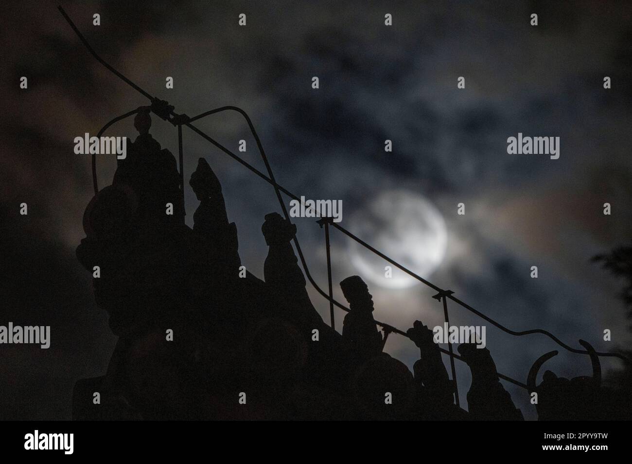 Roof decorations depicting mythical sacred beasts are silhouetted near ...