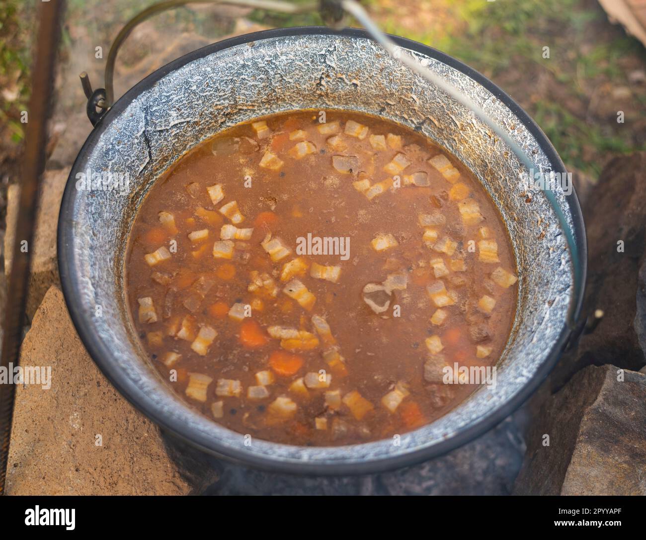 Delicious meal (goulash) made on traditional way in fish pot on camp ...