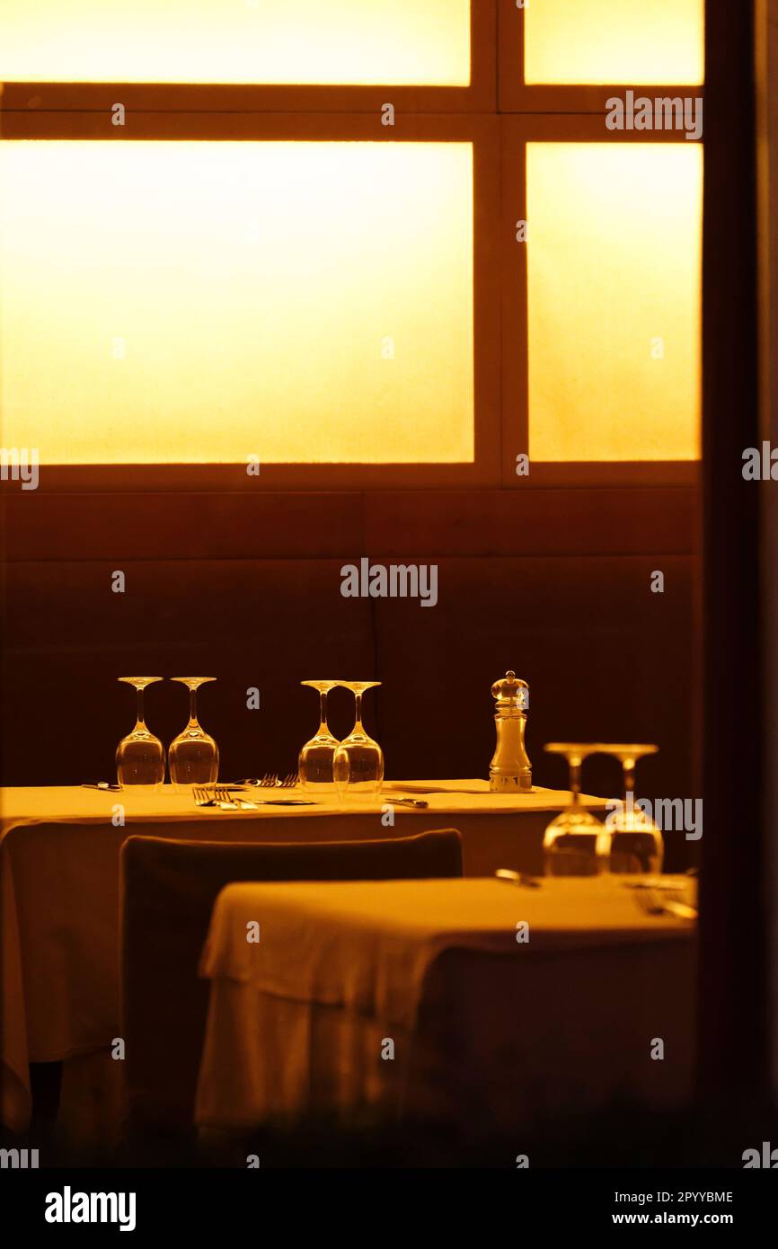 An interior view of a cozy restaurant dining area, with warm sunlight ...