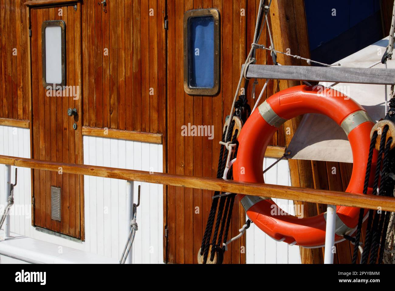 A red lifebuoy attached to the railing of a boat deck Stock Photo - Alamy