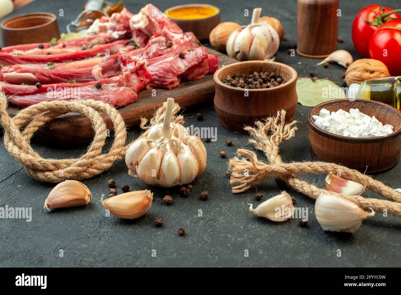 front view raw meat slice with fresh vegetables and seasonings on dark ...