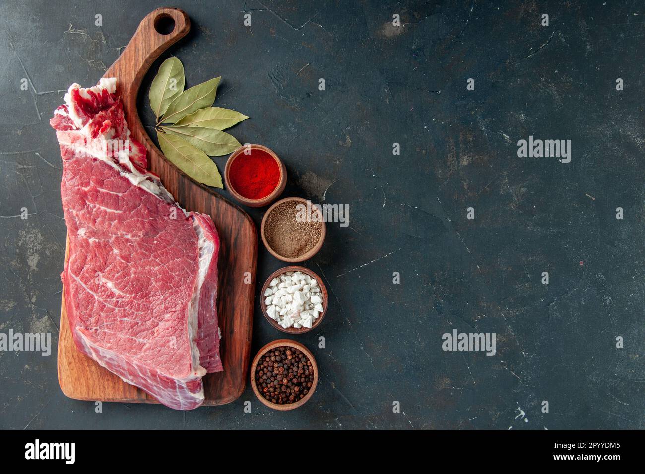 top view raw meat slice with seasonings on dark background color ...