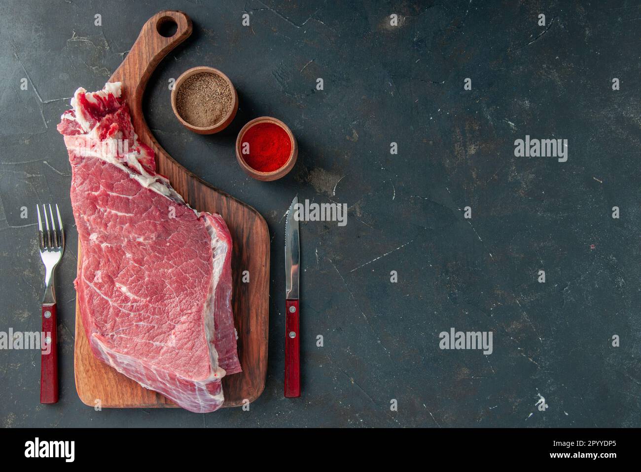 top view raw meat slice with seasonings on dark background color ...